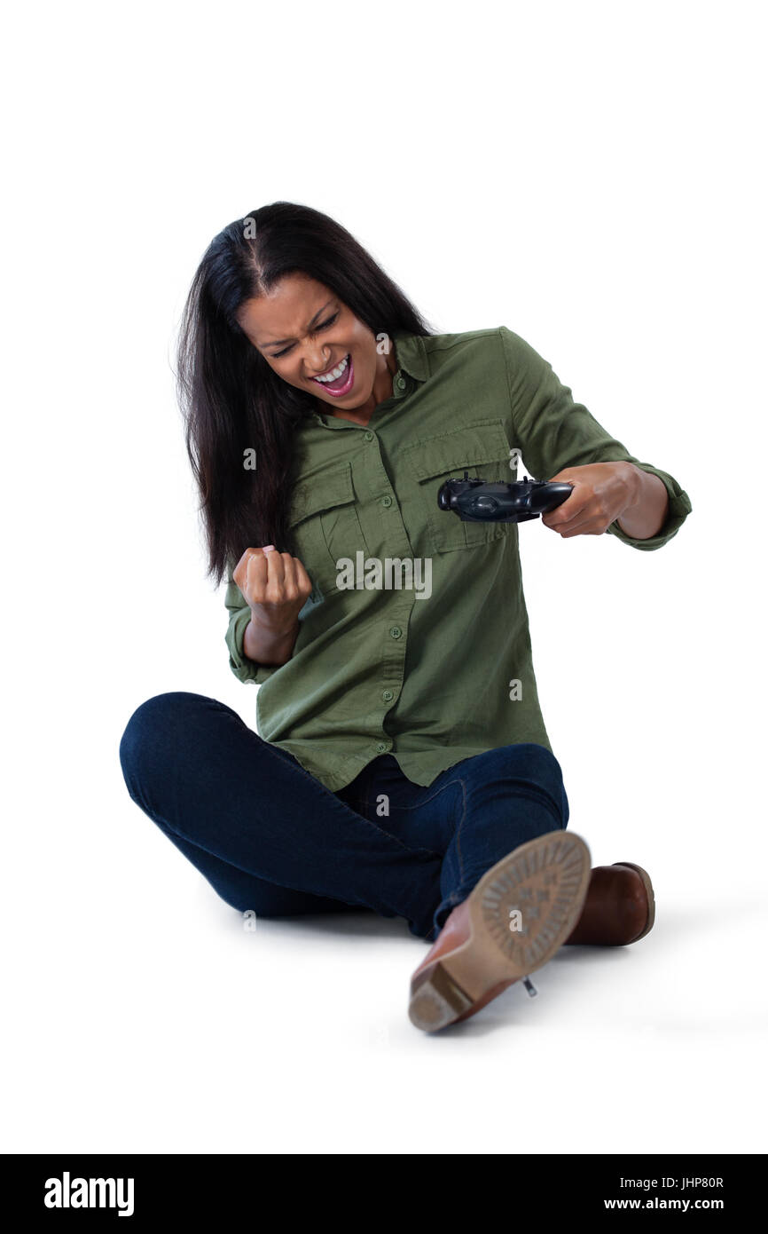 Excited woman playing video games against white background Stock Photo ...