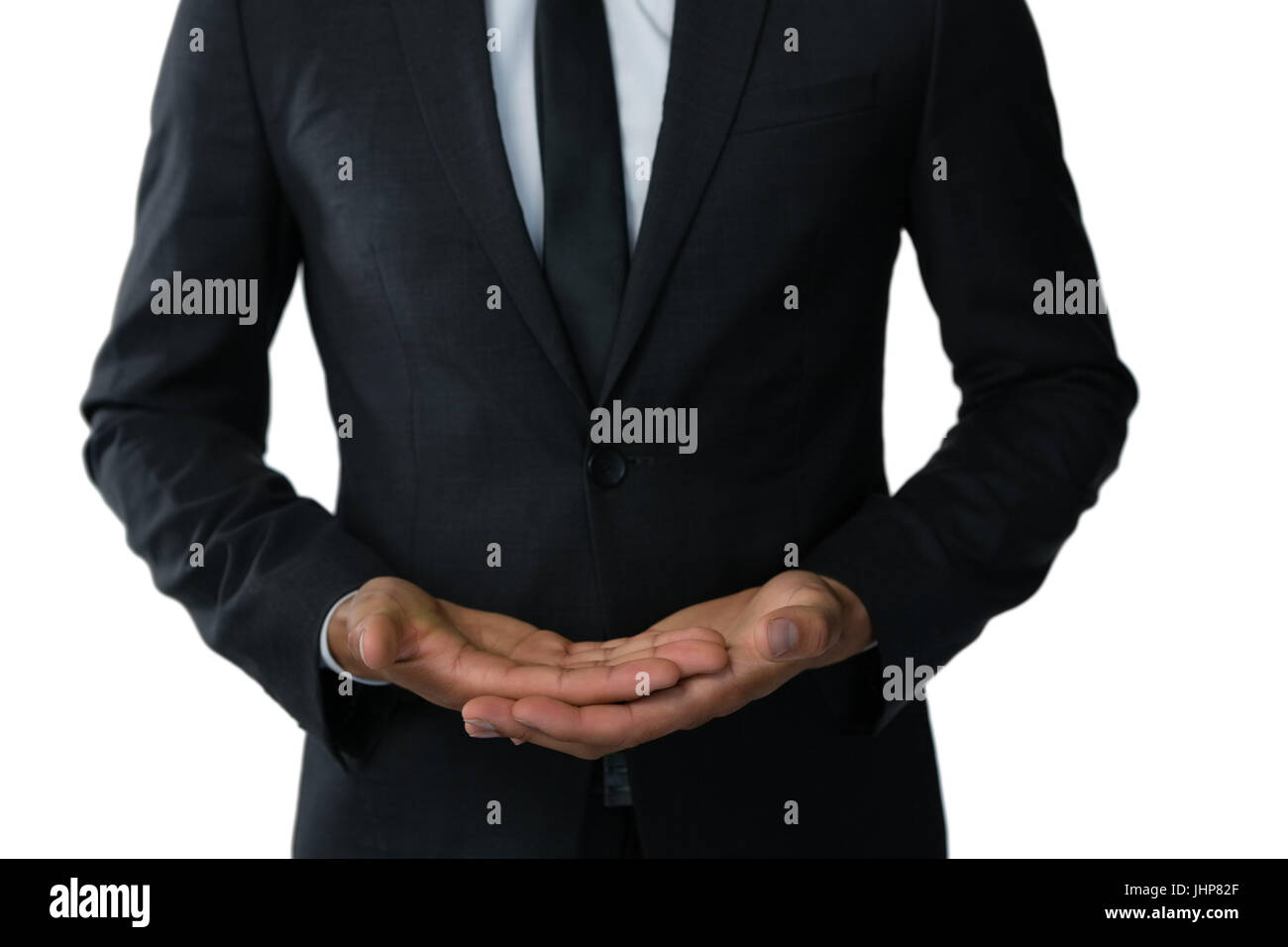 Mid section of businessman doing hand gesture while standing against ...