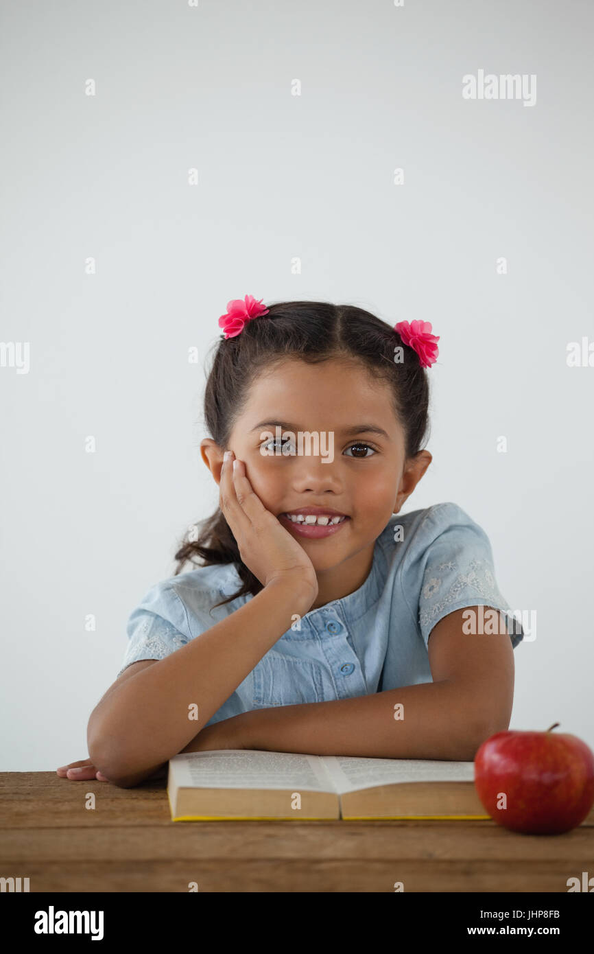 Portrait of young girl sitting on her desk Stock Photo - Alamy