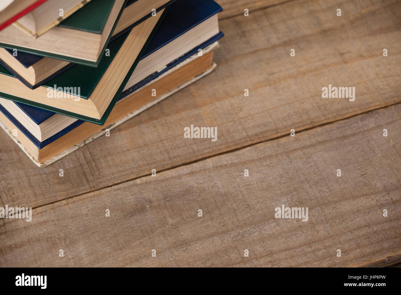 Top view of stack of books on wooden background Stock Photo - Alamy