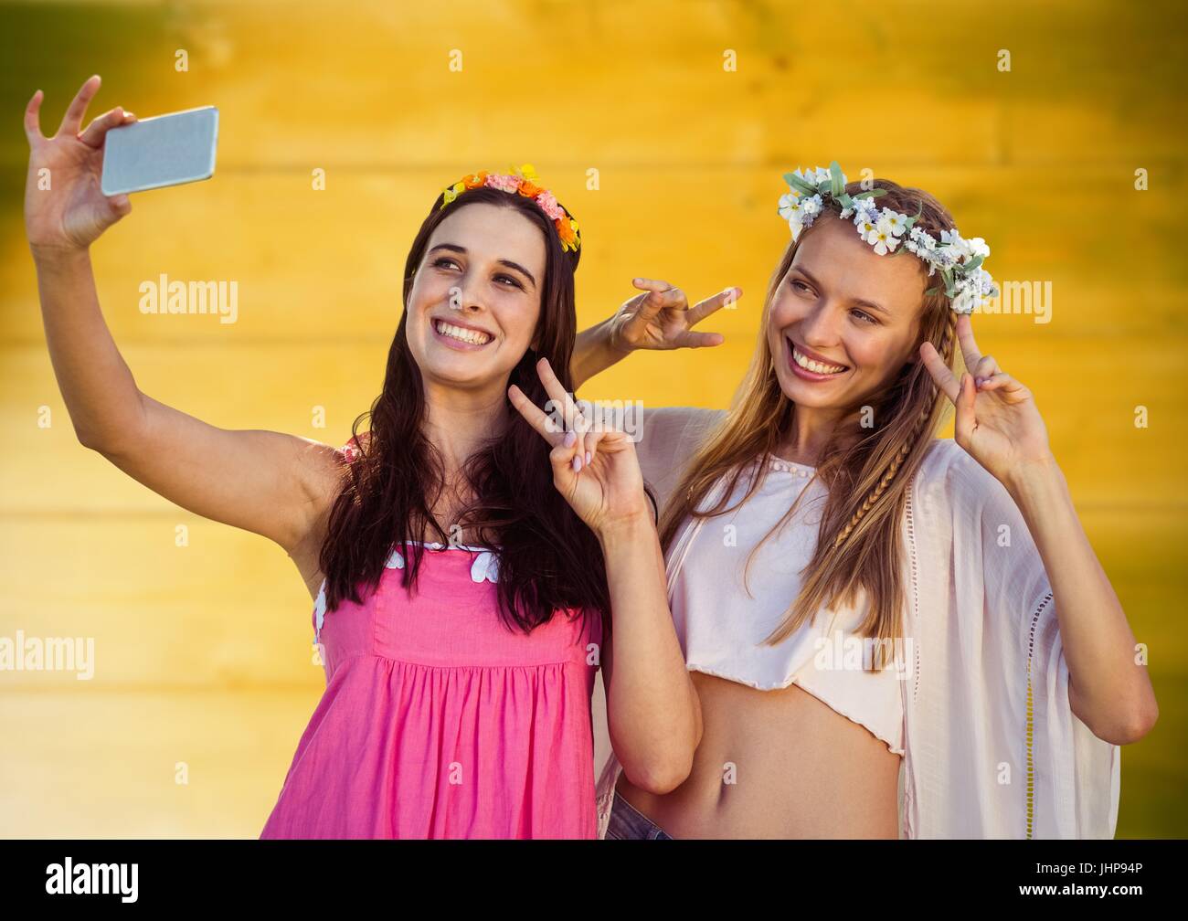 Digital Composite Of Hippie Girls Taking Selfie Against Blurry Yellow
