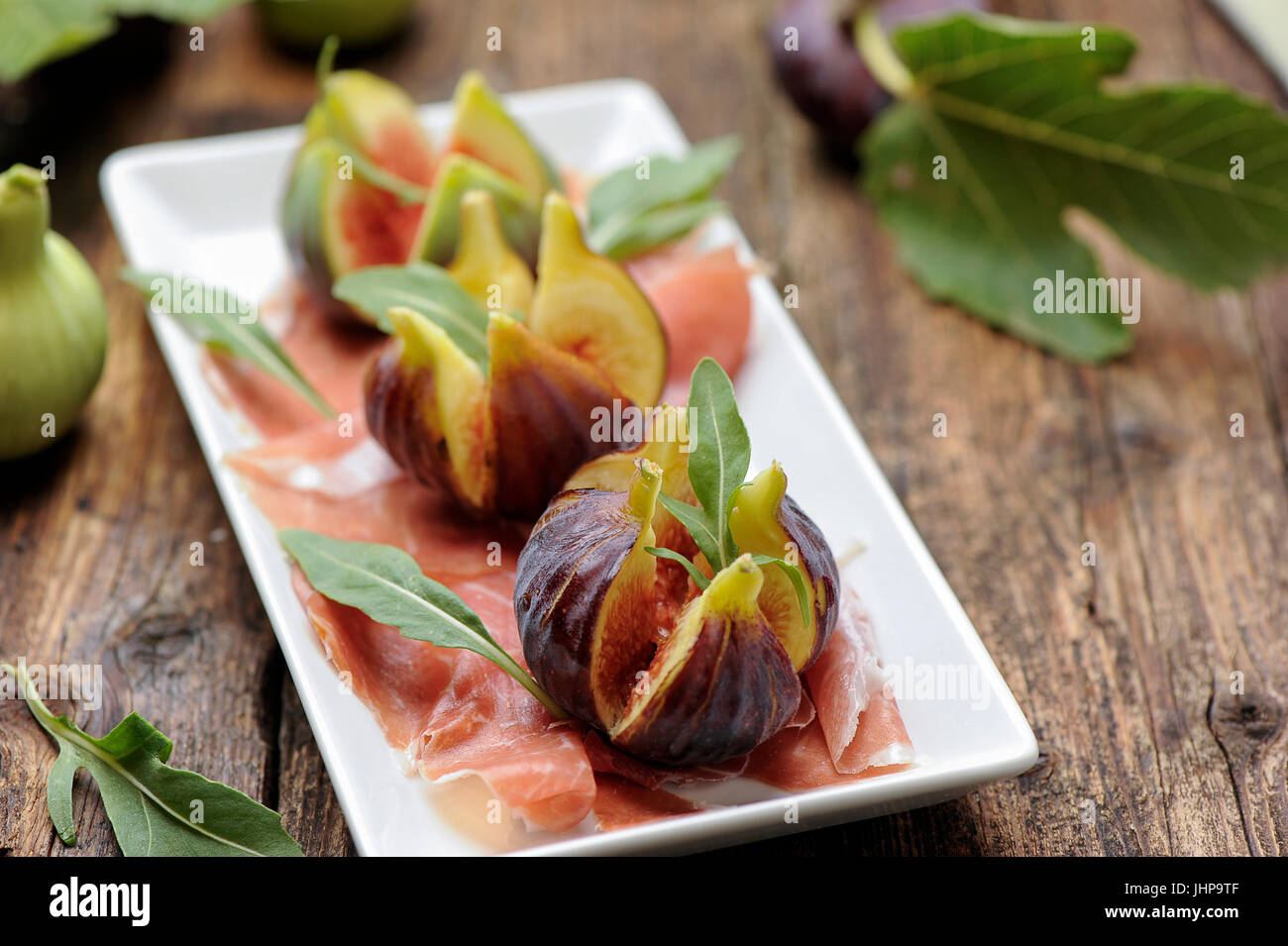 Fresh figs with ham on a white plate Stock Photo - Alamy