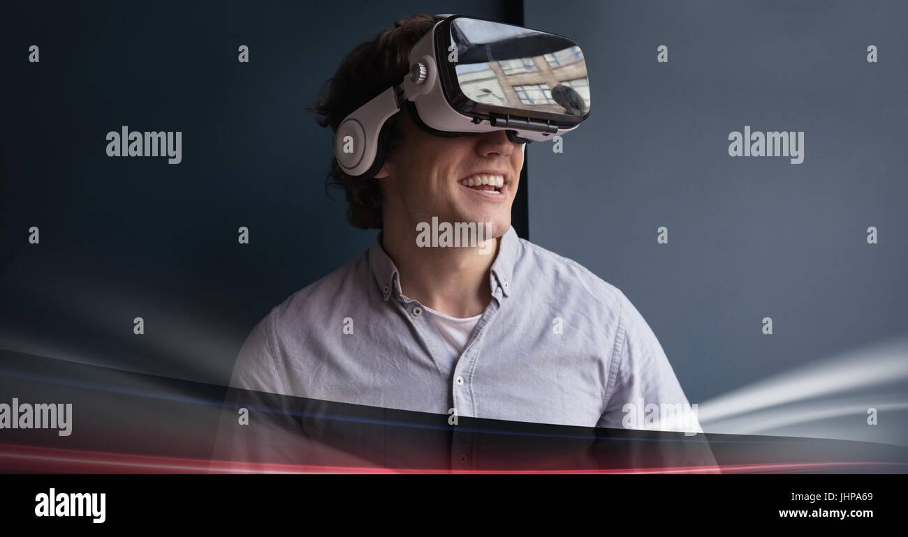 Digital composite of Man in VR headset smiling against blue background ...