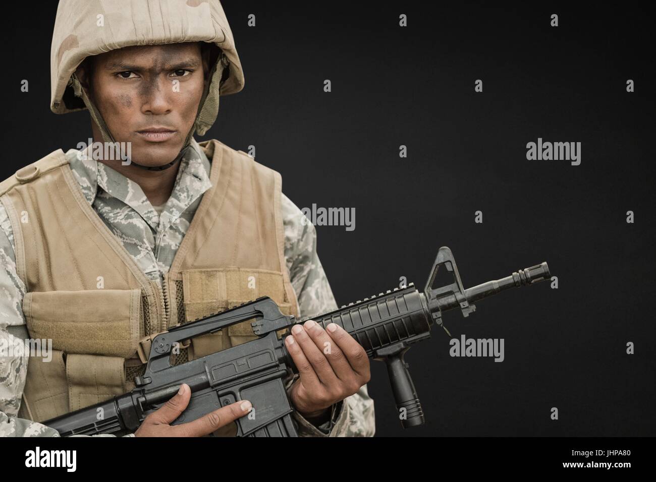 Digital composite of Angry soldier man holding a weapon against black ...