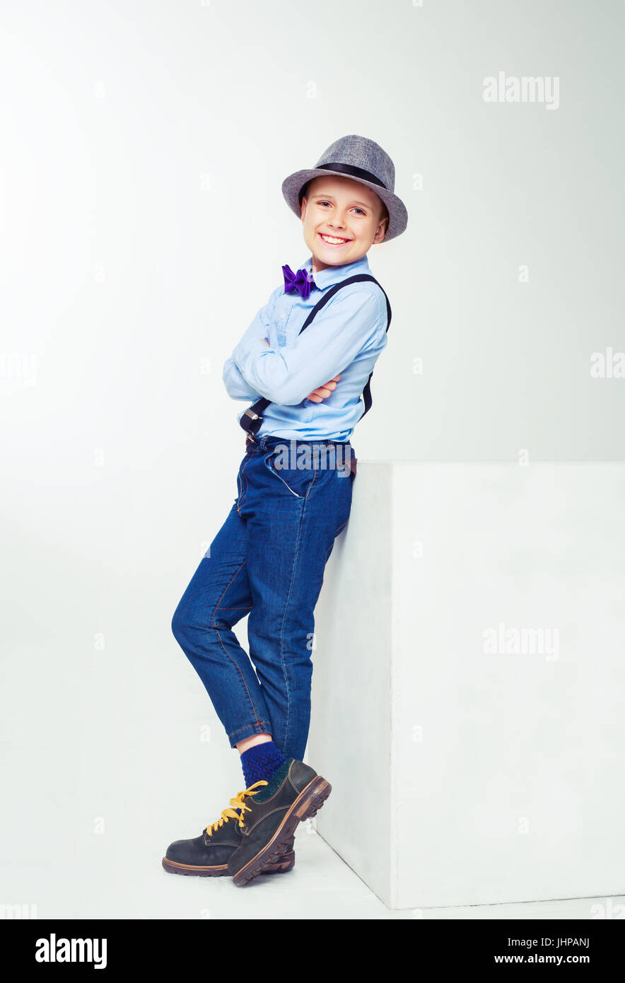 happy stylish boy wearing a hat and a tie, against white background ...