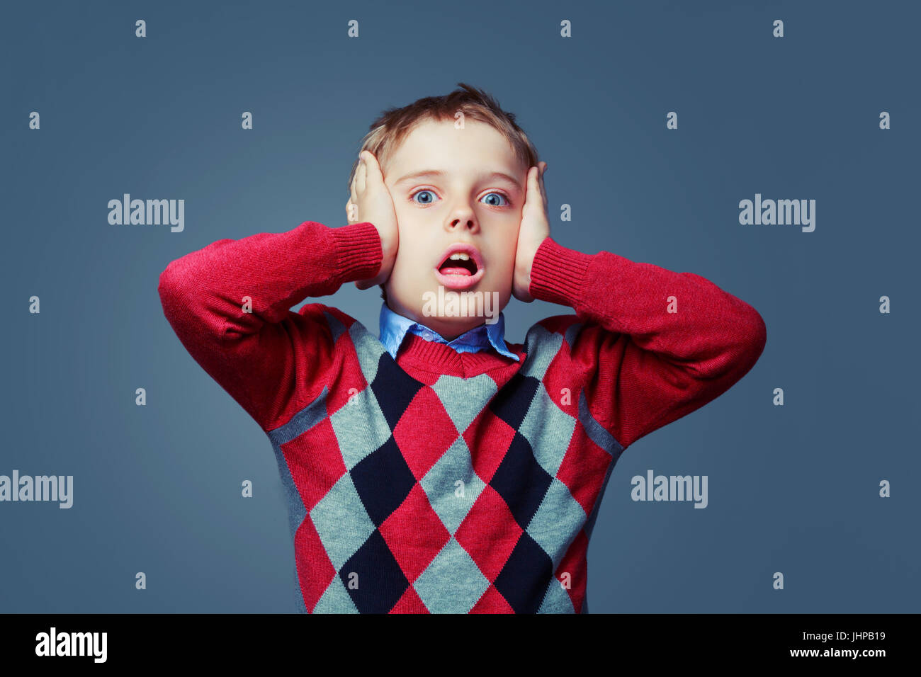 scared boy isolated against grey background Stock Photo - Alamy
