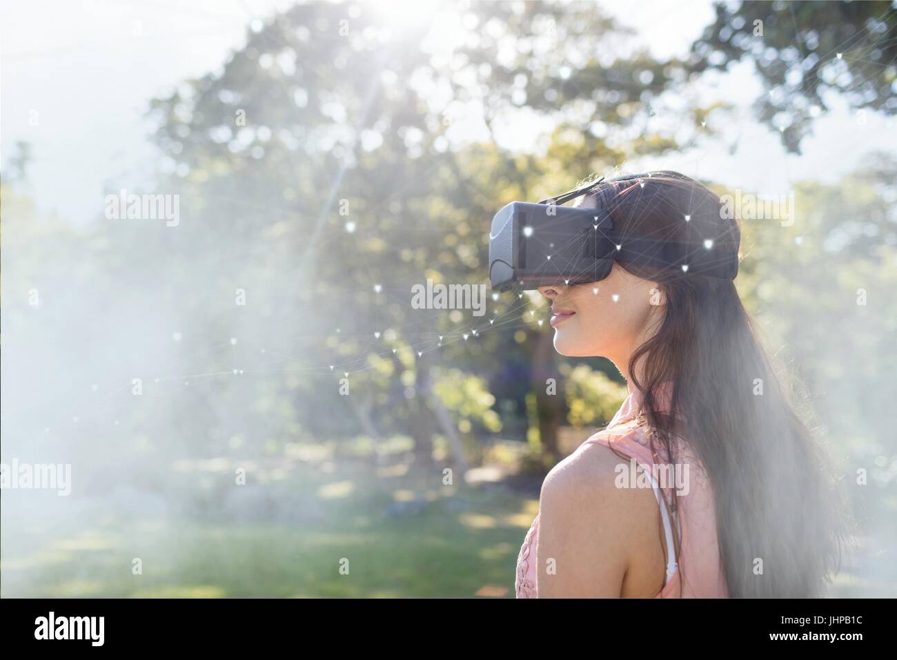Digital composite of Woman in VR headset looking at stars interface ...