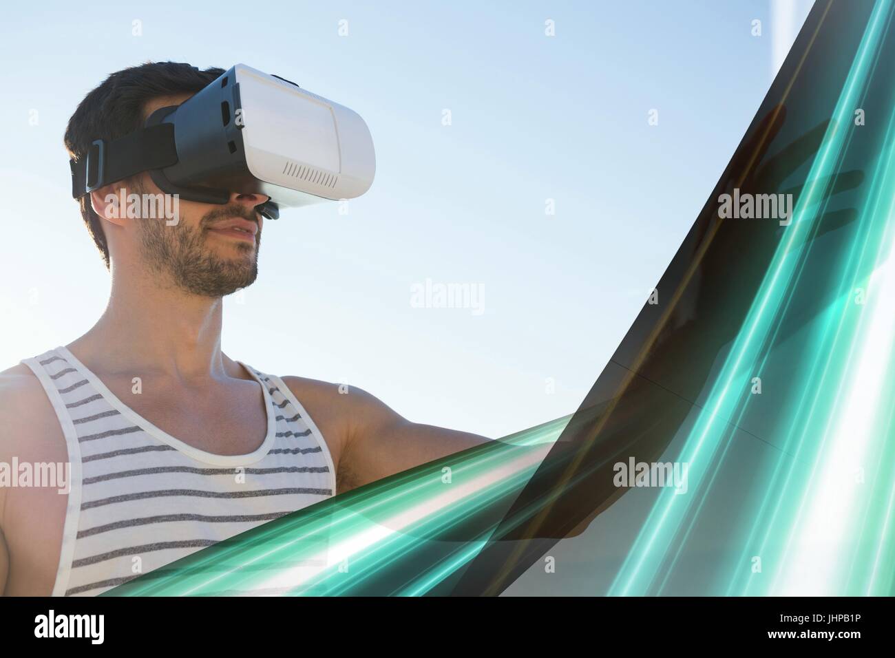 Digital composite of Man in VR headset touching green light interface ...