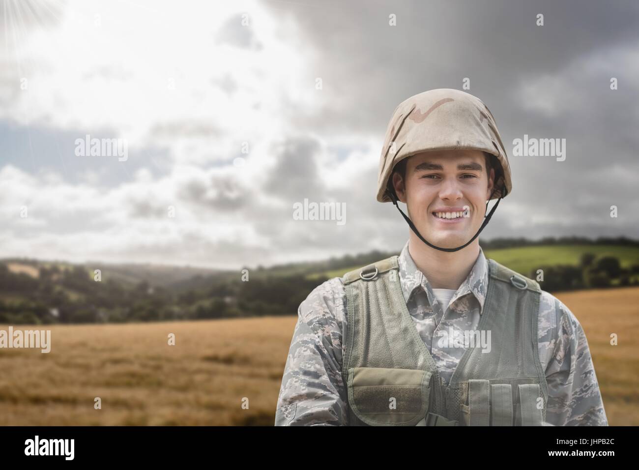 Digital composite of Happy soldier man standing against field ...
