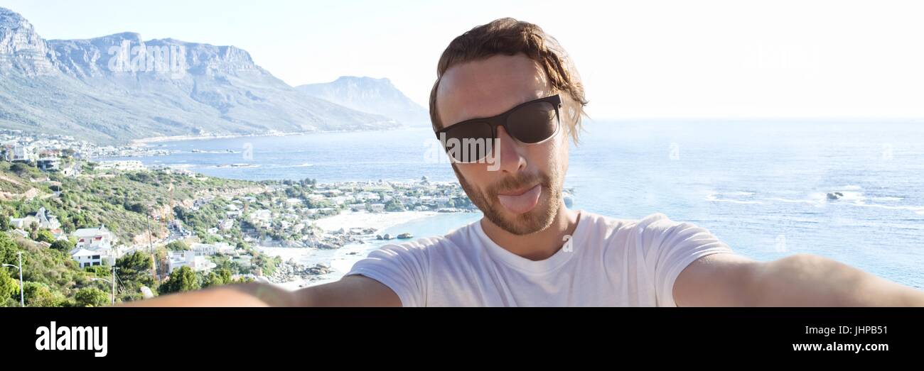 Digital composite of Millennial man taking selfie and sticking out ...