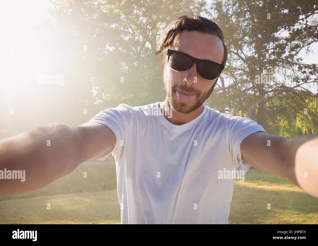 Digital composite of Millennial man taking selfie and stick out tongue ...