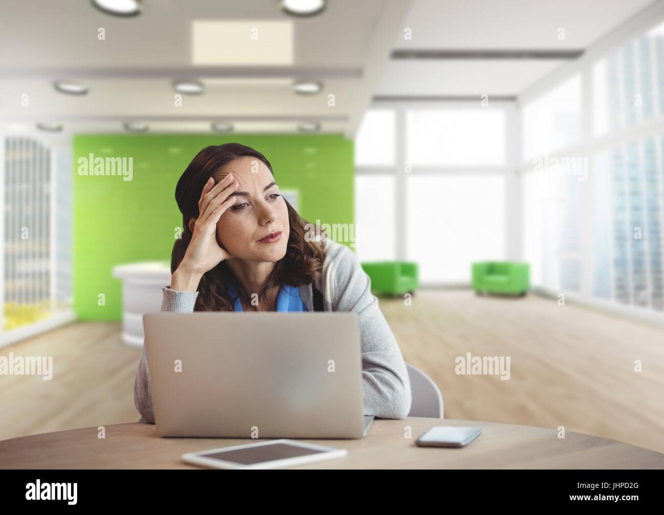 Digital composite of Worried business woman at a desk using a computer ...
