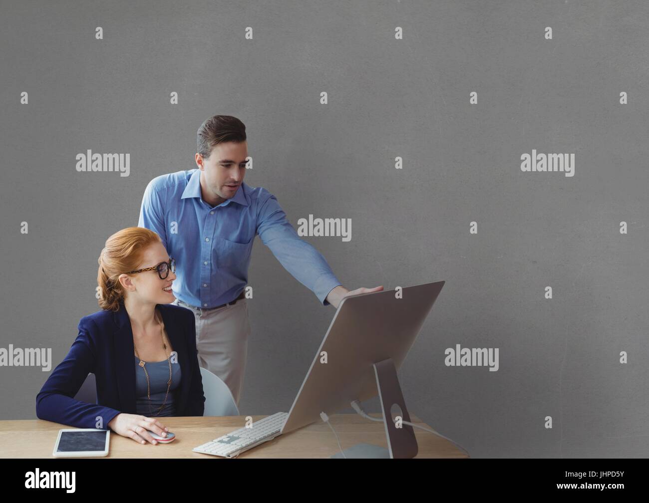 Digital composite of Business people at a desk looking at a computer ...