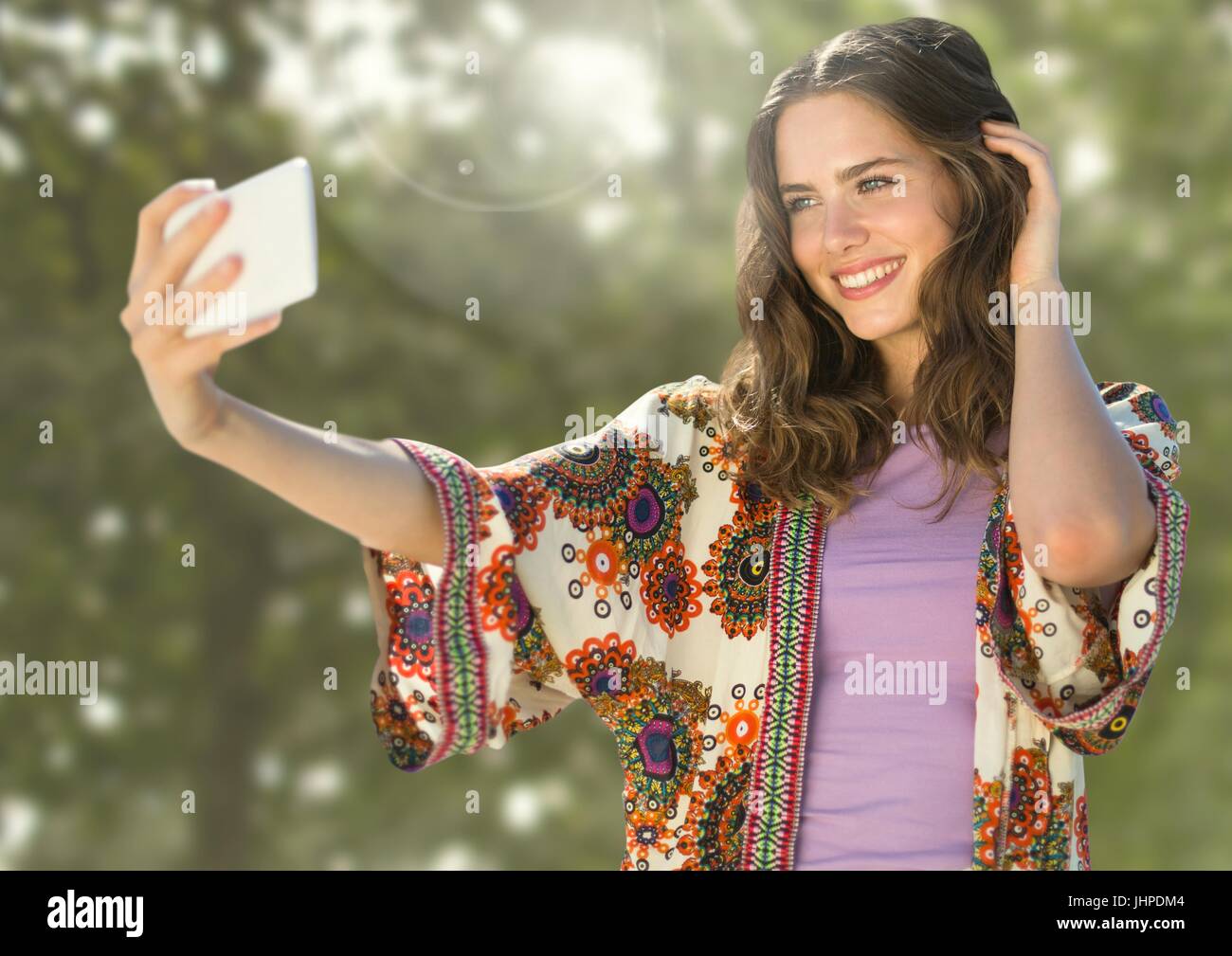 Digital composite of Woman taking casual selfie photo in front of green ...