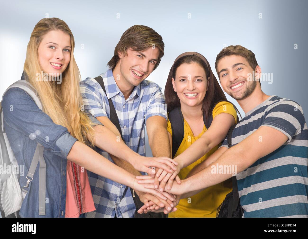 Digital composite of Students joing hands together in front of blurred ...