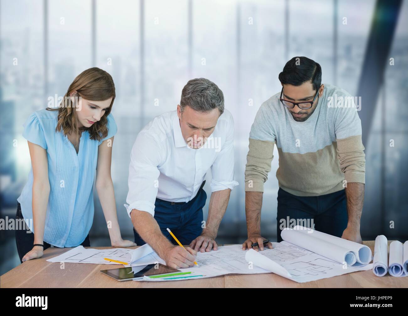 Digital composite of Business people at a desk looking at a paper Stock ...