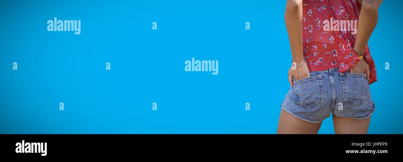 Digital composite of Back of millennial woman lower body against blue ...