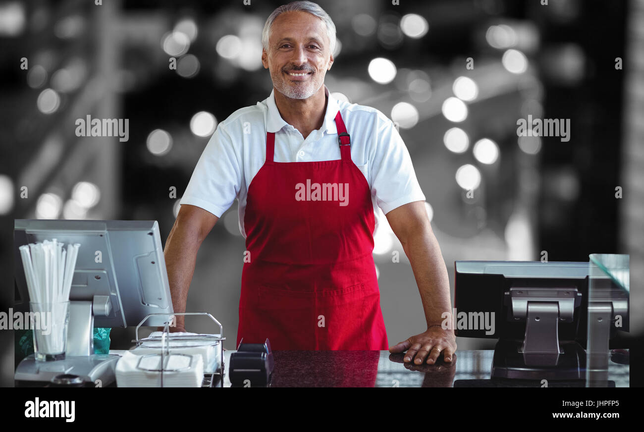 Portrait of male owner standing at counter against glowing road in city ...