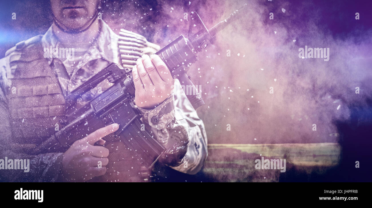 Scenic view of green field against military soldier carrying a rifle ...