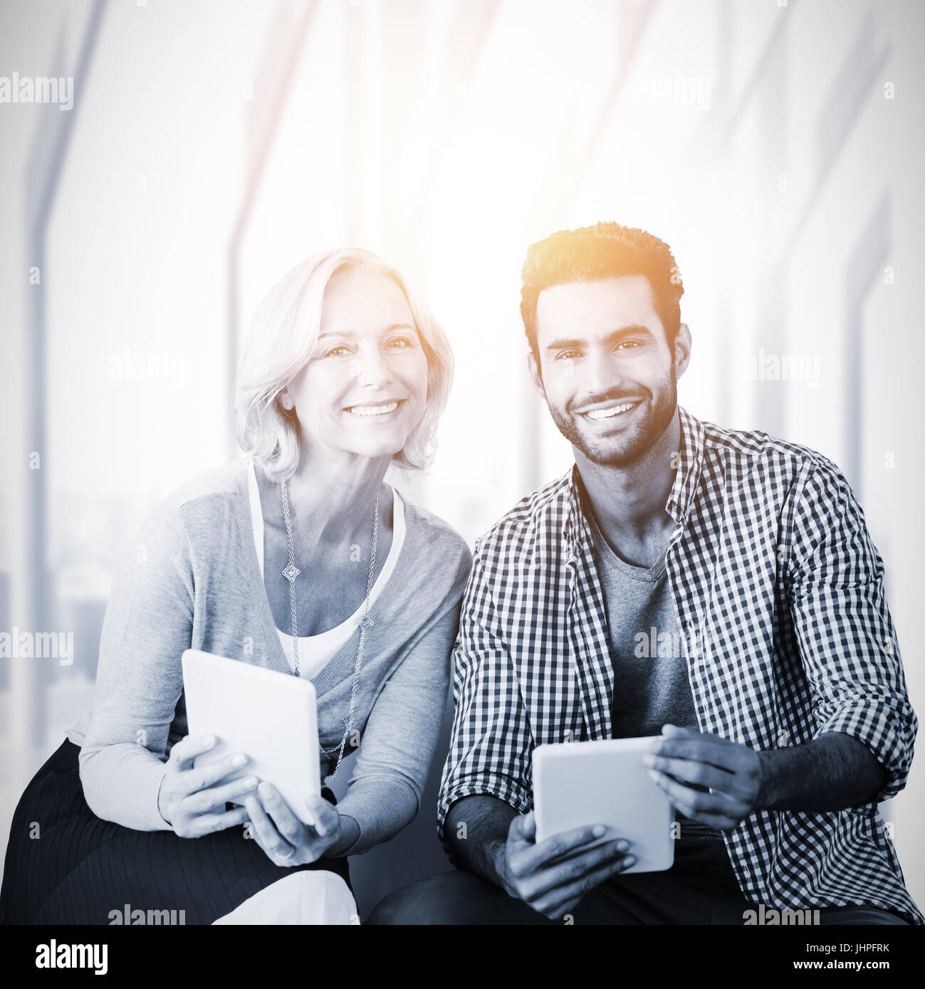 Smiling business people looking at camera against room with large ...