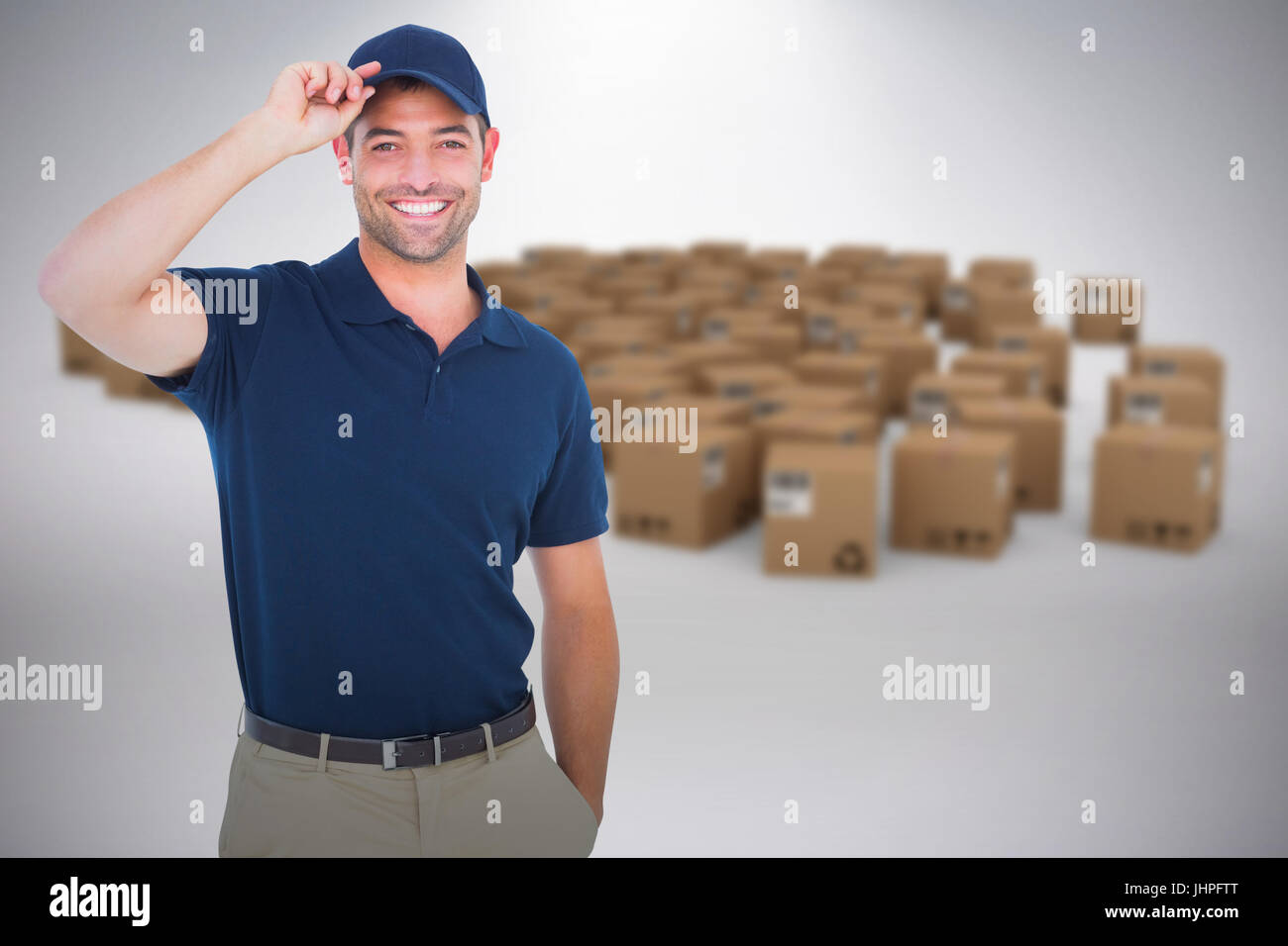 Portrait of happy delivery man wearing cap against grey background ...