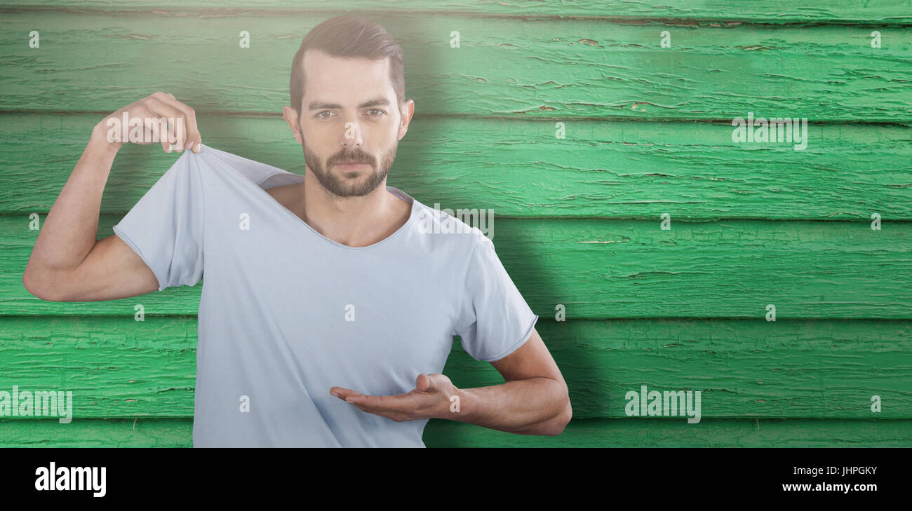 Portrait of male model showing cloth against full frame shot of green ...
