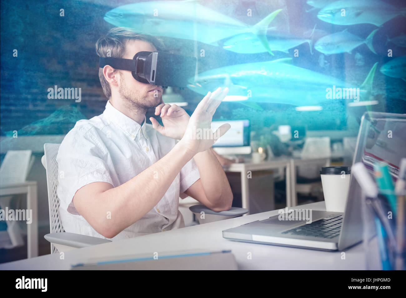 Fish swimming in a tank against executive gesturing while using virtual ...