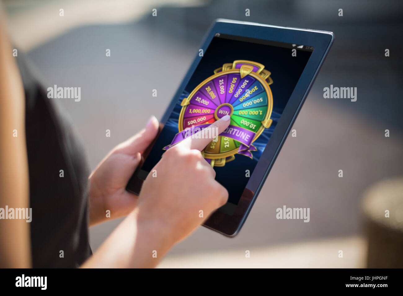 Colorful wheel of fortune on mobile display against businesswoman using ...