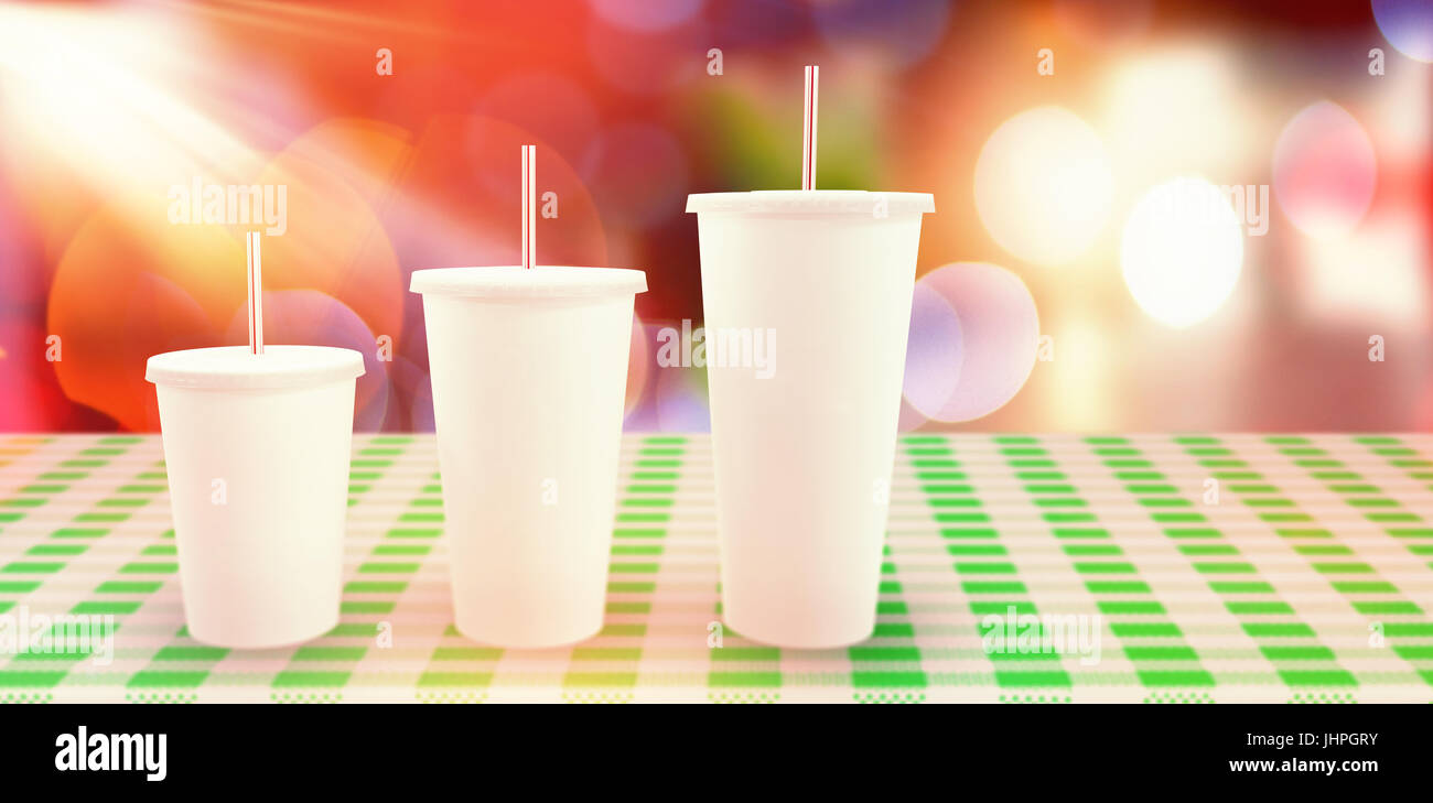 Glass of gin on bar counter against white cups over white background ...