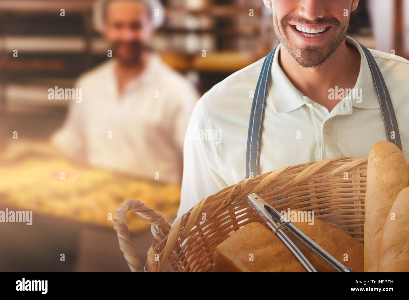 Baker holding bread in whisker basket against portrait of female baker ...