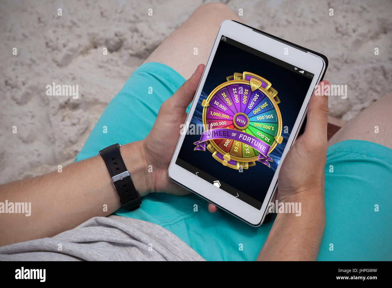 Colorful wheel of fortune on mobile display against man using digital ...