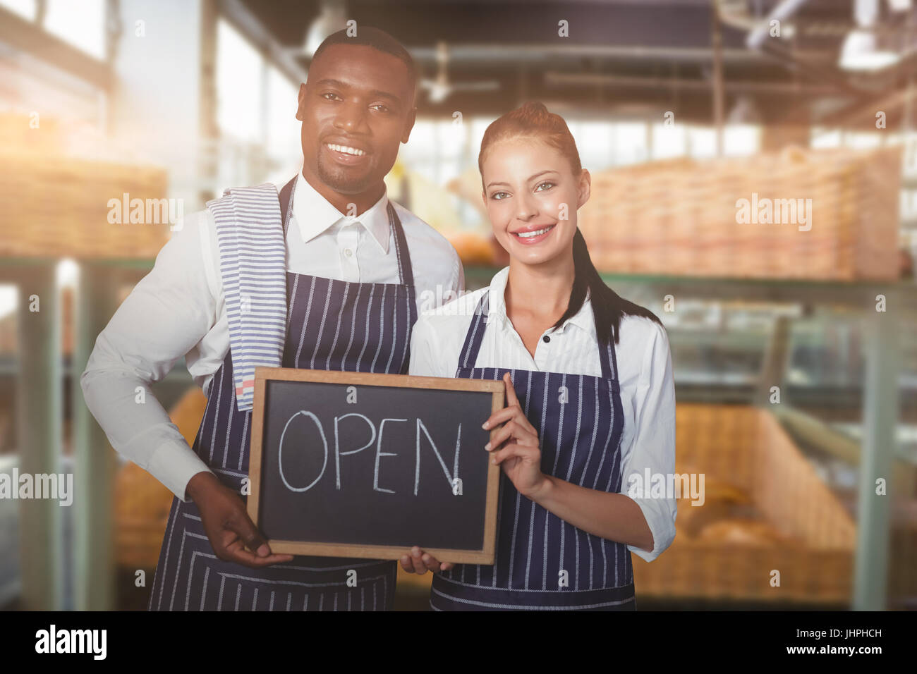 Portrait of smiling wait staff holding writing slate with text against ...