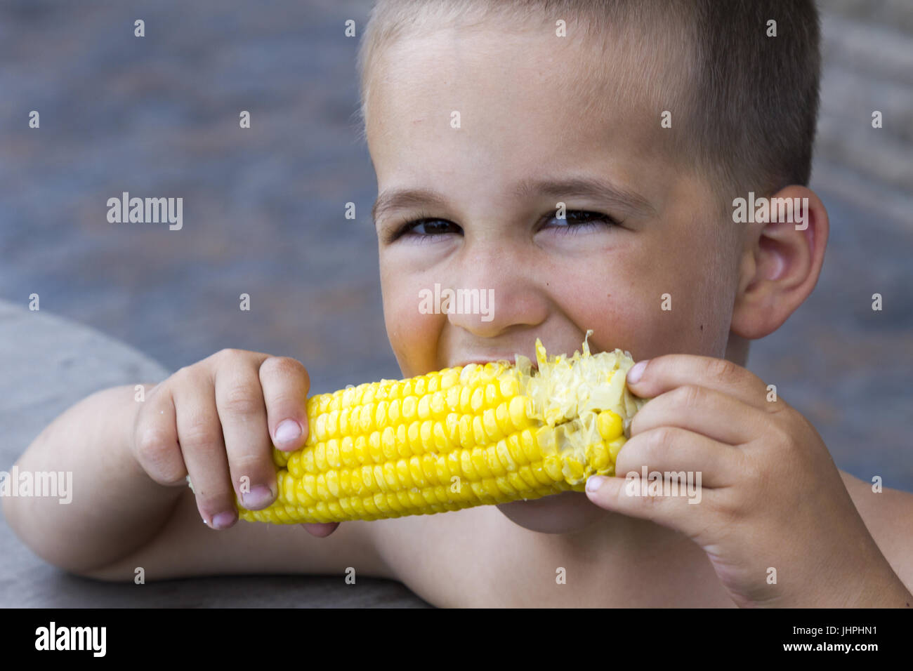 Boy eating fresh boiled corn Stock Photo - Alamy