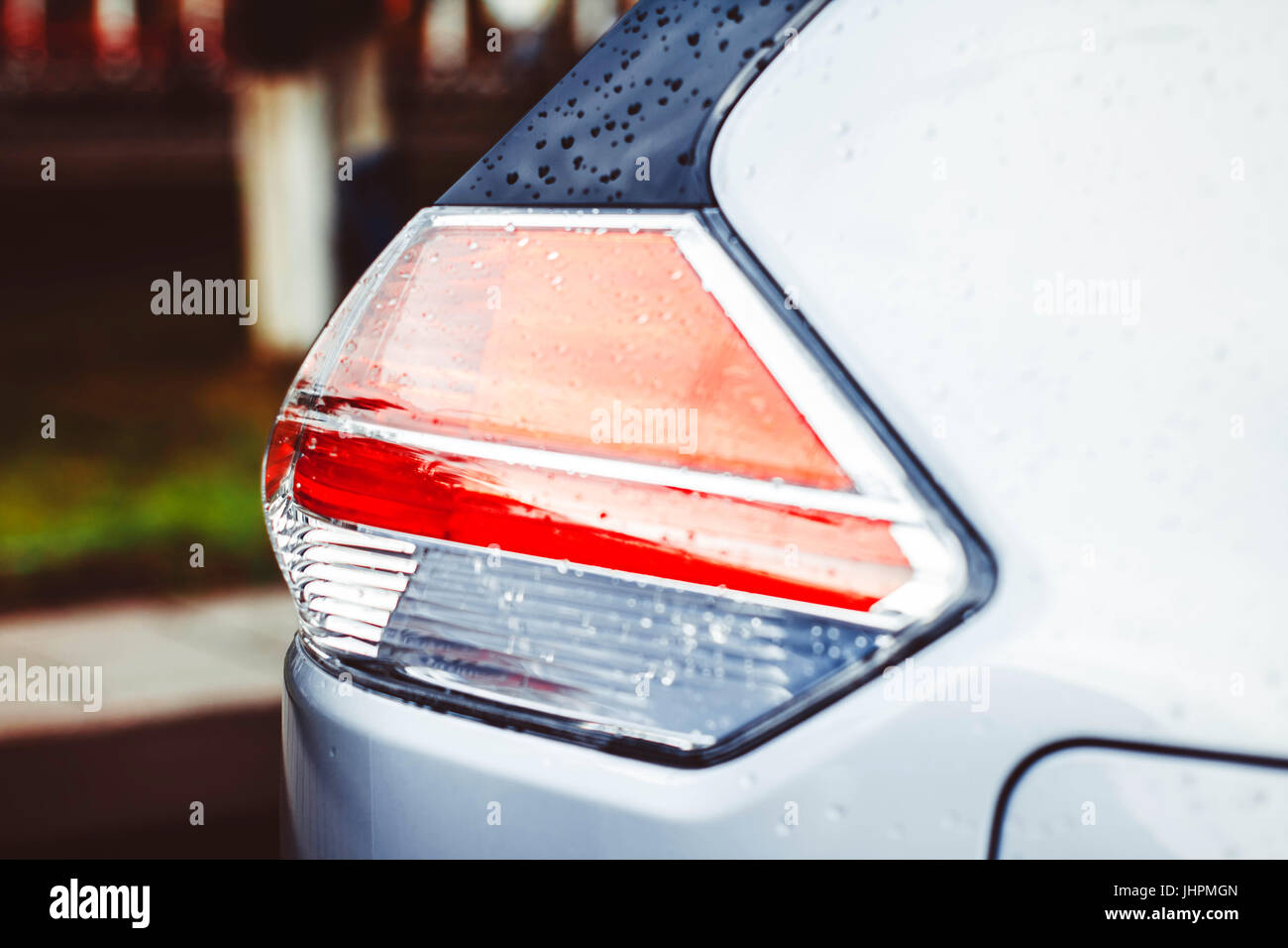 Modern blue car tail light in wet rain drop. Red modern car back light ...