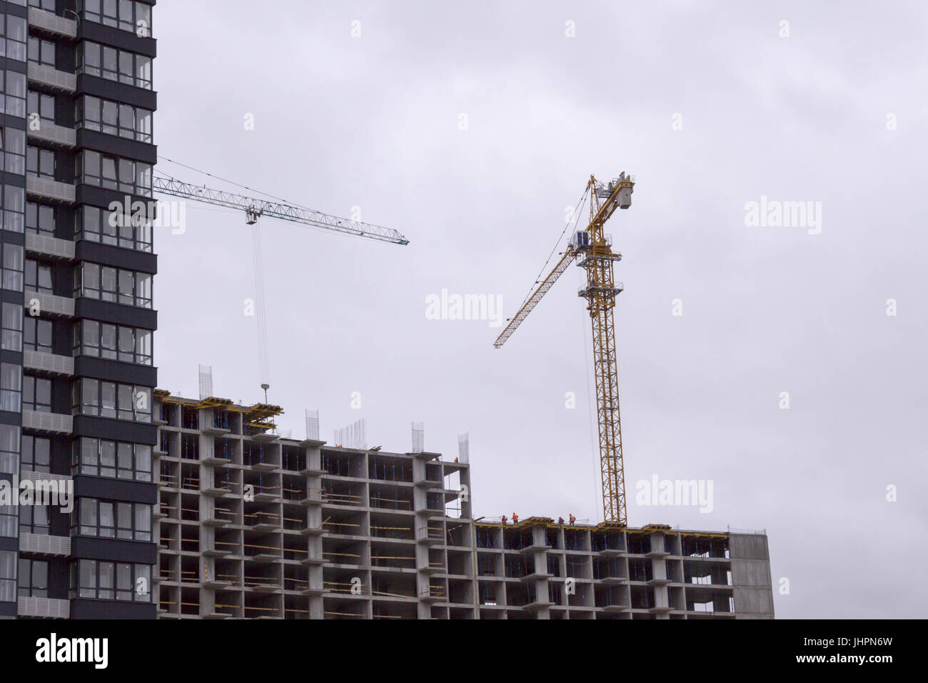 Working tall cranes inside place for with tall buildings under ...