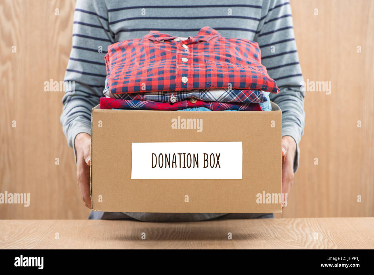 Donation box for poor with clothing in male hands Stock Photo - Alamy