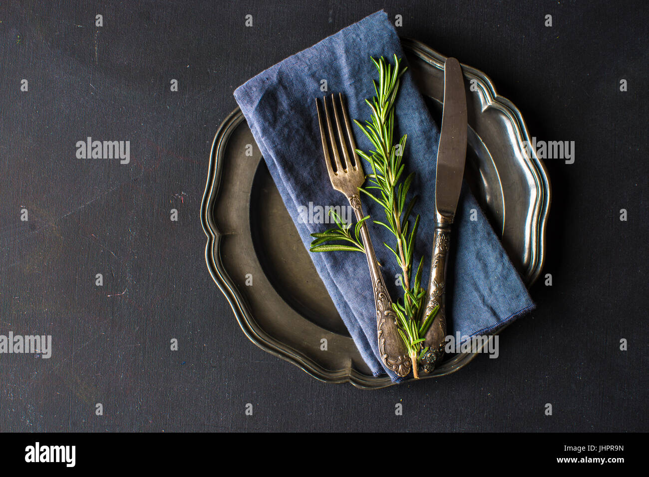 Rustic table setting with empty plate and vintage silverware decorated ...