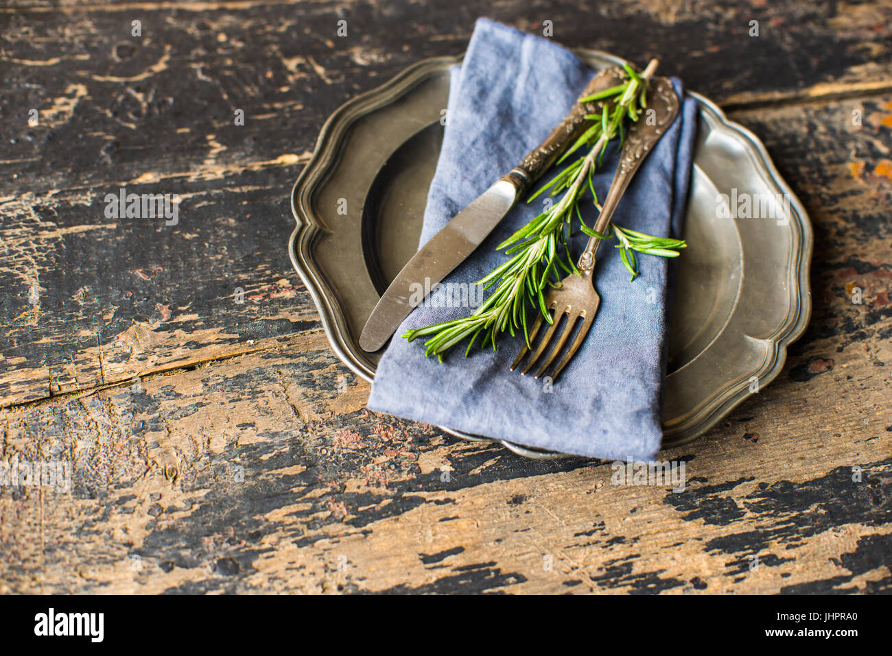 Rustic table setting with empty plate and vintage silverware decorated ...