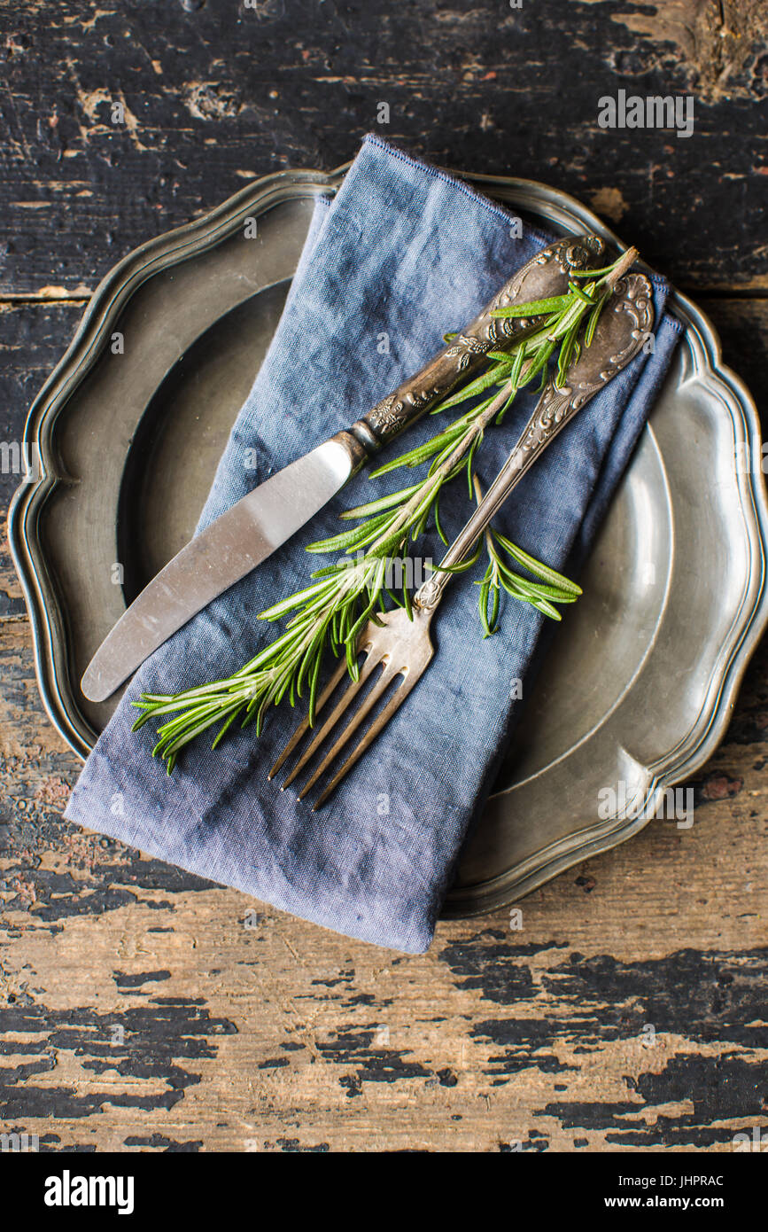 Rustic table setting with empty plate and vintage silverware decorated ...