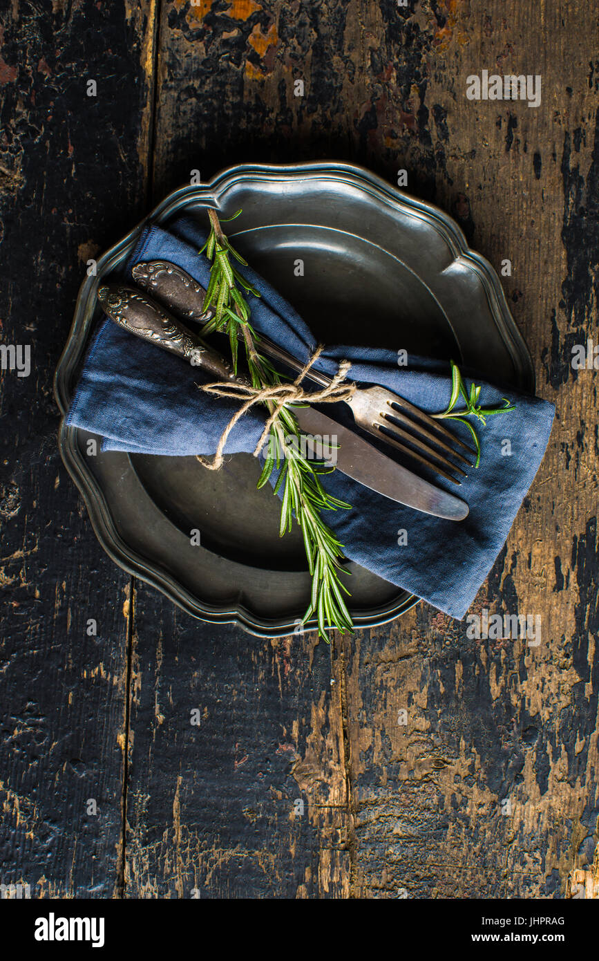 Rustic table setting with empty plate and vintage silverware decorated ...