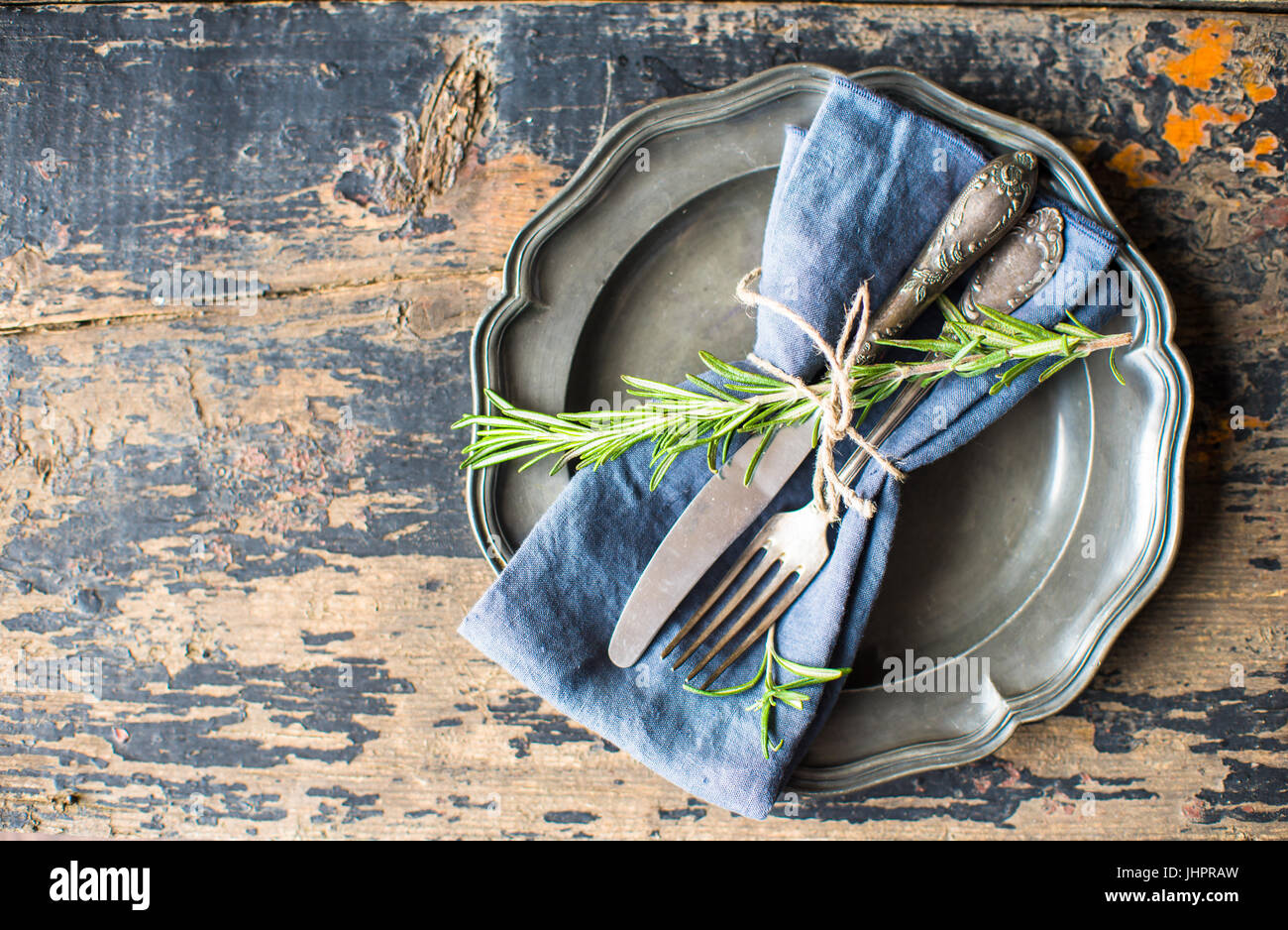 Rustic table setting with empty plate and vintage silverware decorated ...