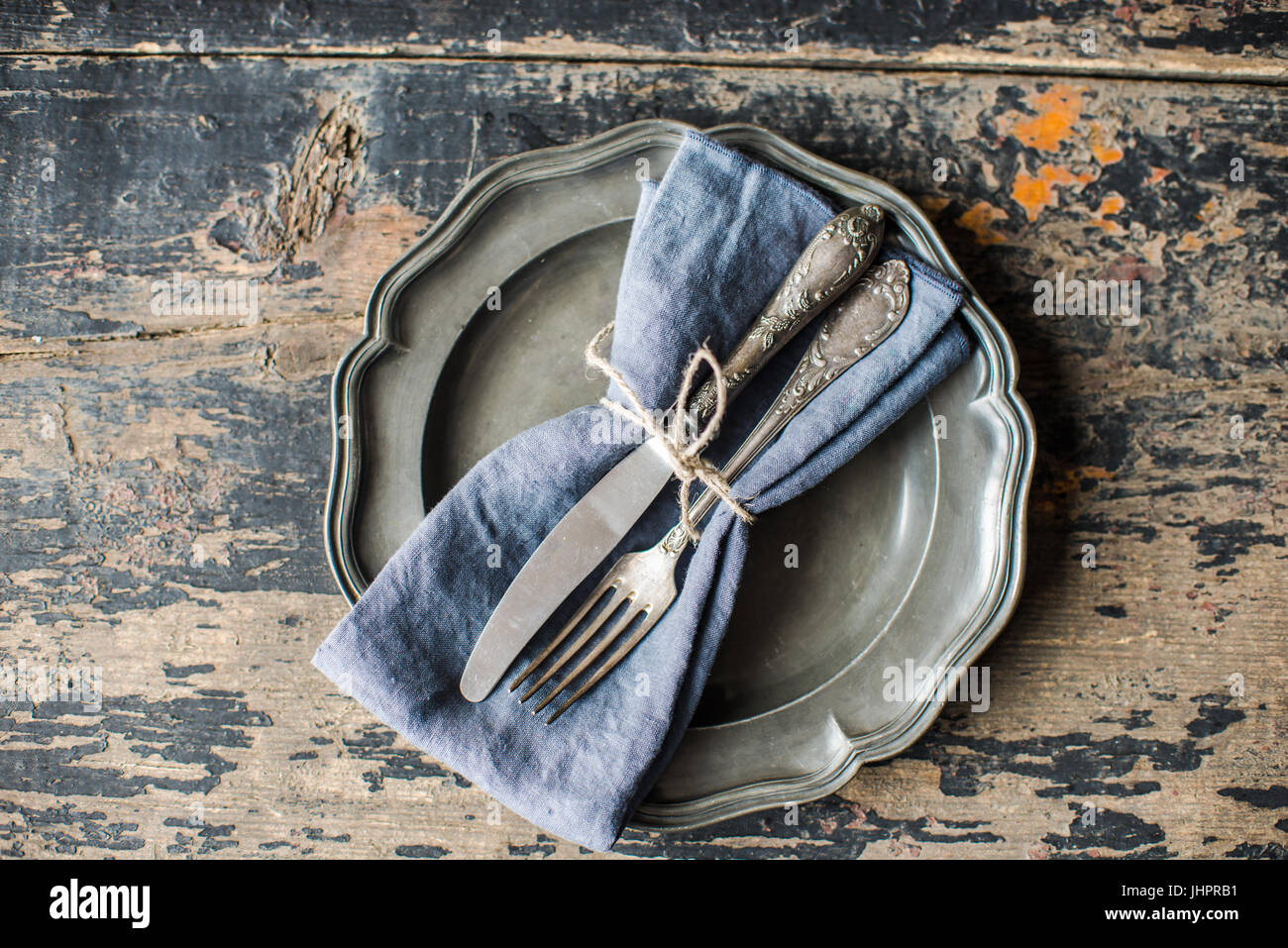Rustic table setting with empty plate and vintage silverware decorated ...