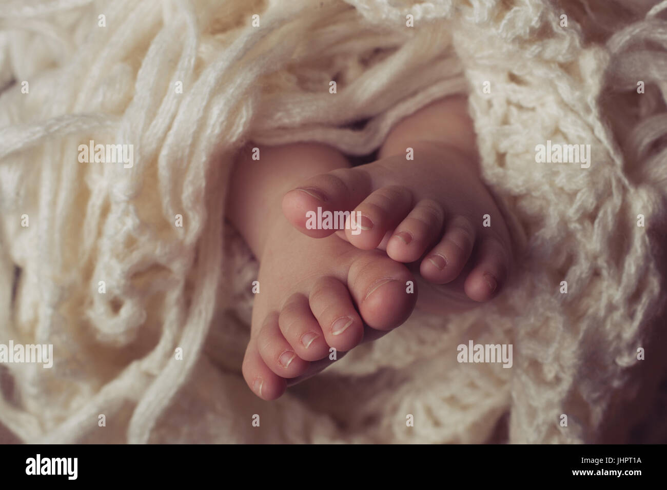 Small legs of newborn wrapped in a blanket Stock Photo - Alamy