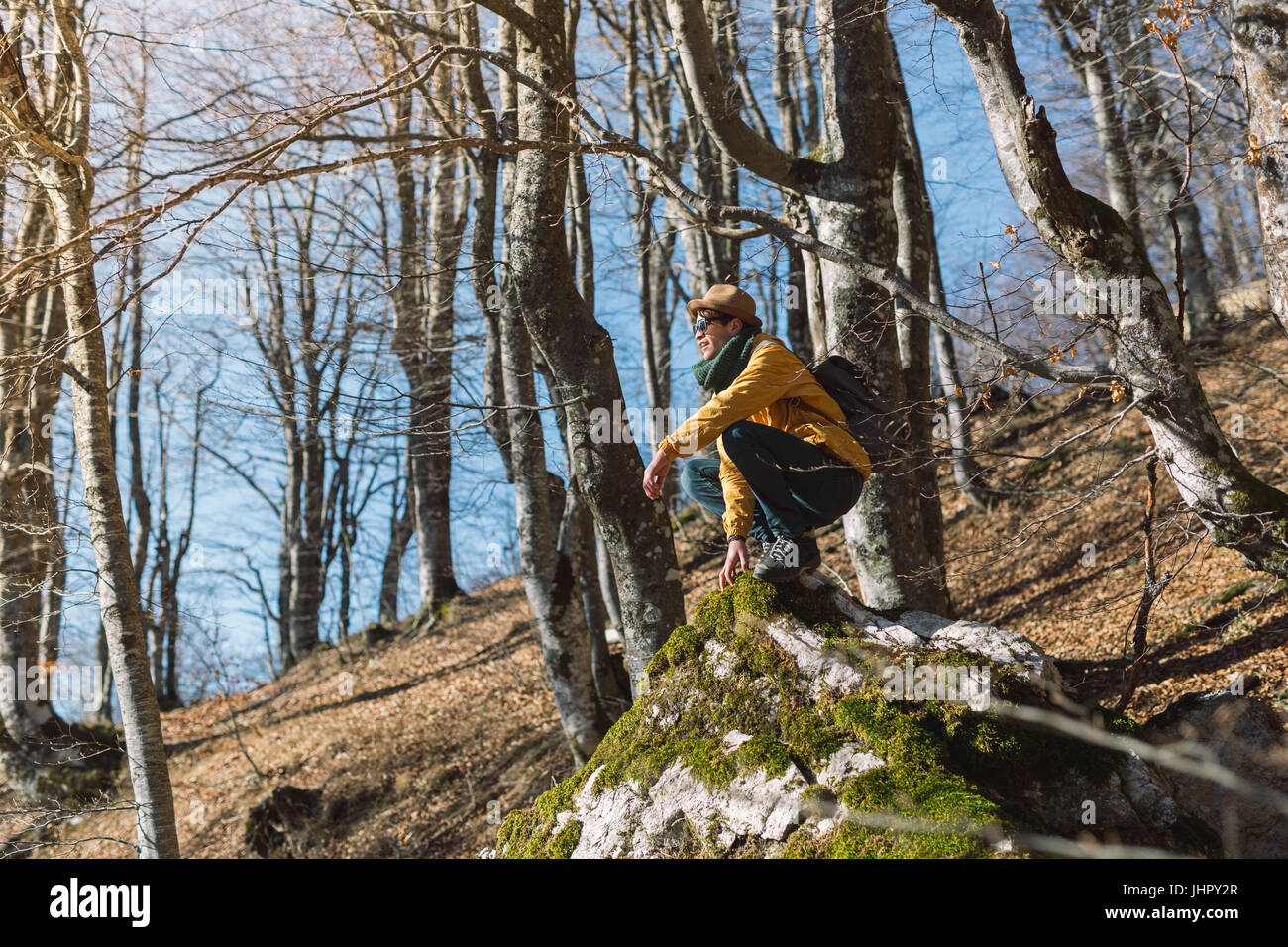Young man standing in the forest and exploring, freedom and nature ...