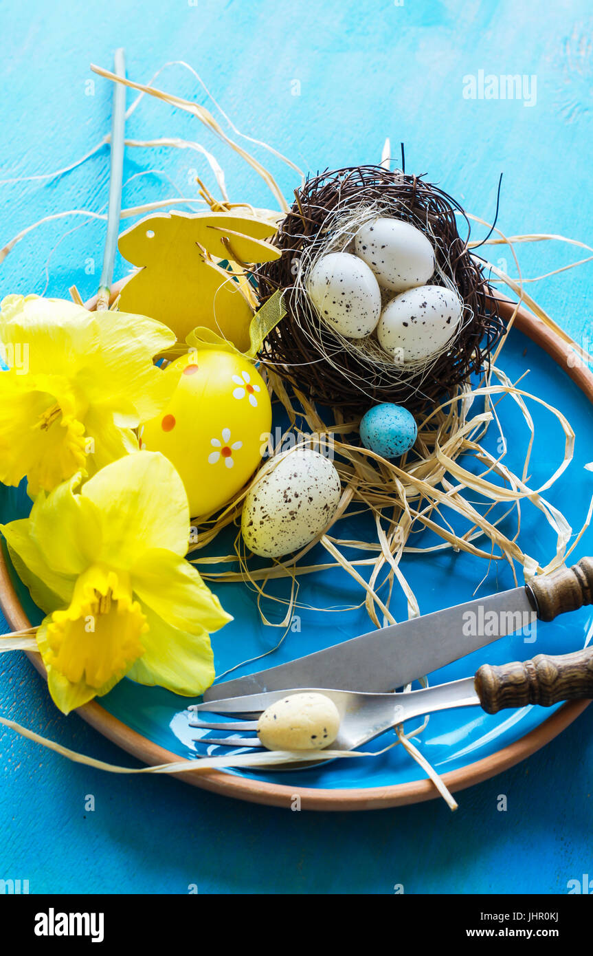 Festive table setting for Easter dinner with bright easter eggs and yellow daffodils Stock Photo ...
