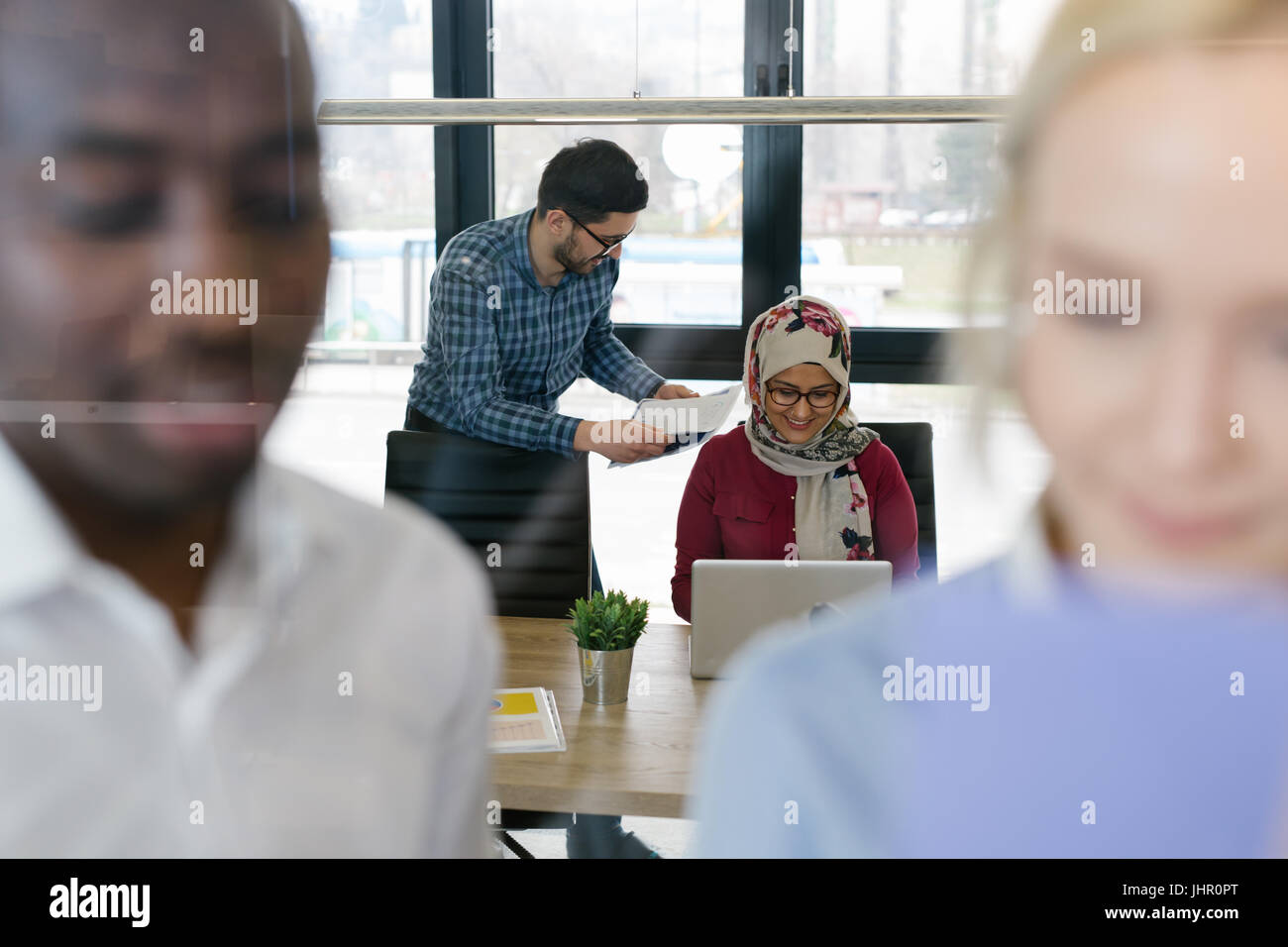 Back view of co-workers writing documents using laptops at workplace in ...