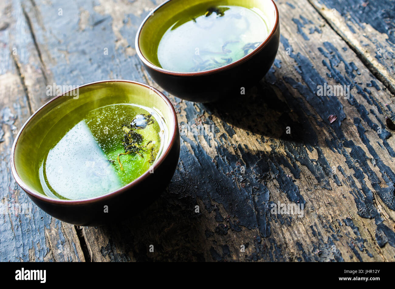 Green tea and leaves on rustic wooden table Stock Photo - Alamy