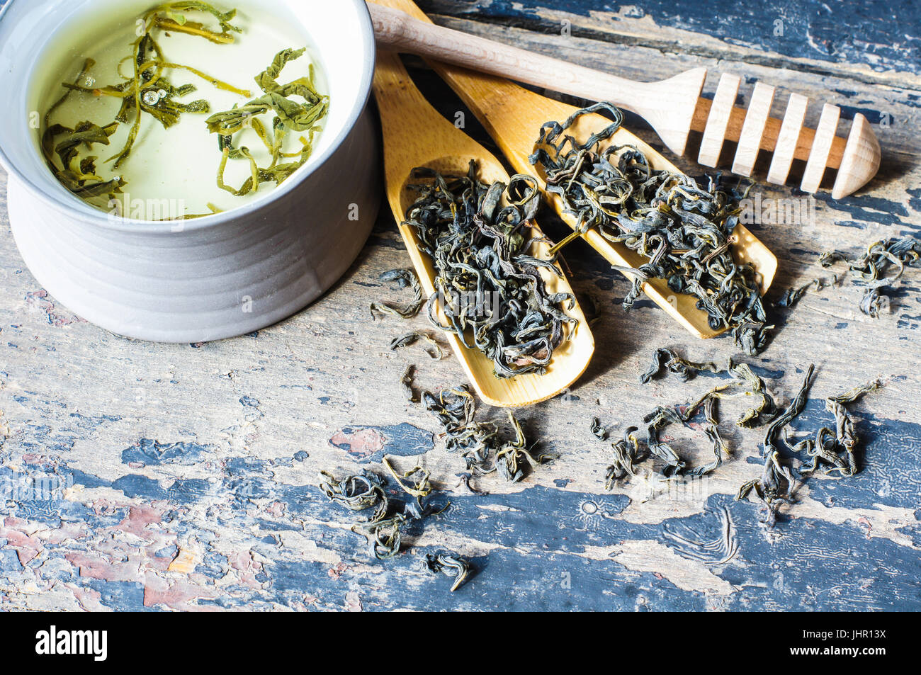Green tea and leaves on rustic wooden table Stock Photo - Alamy
