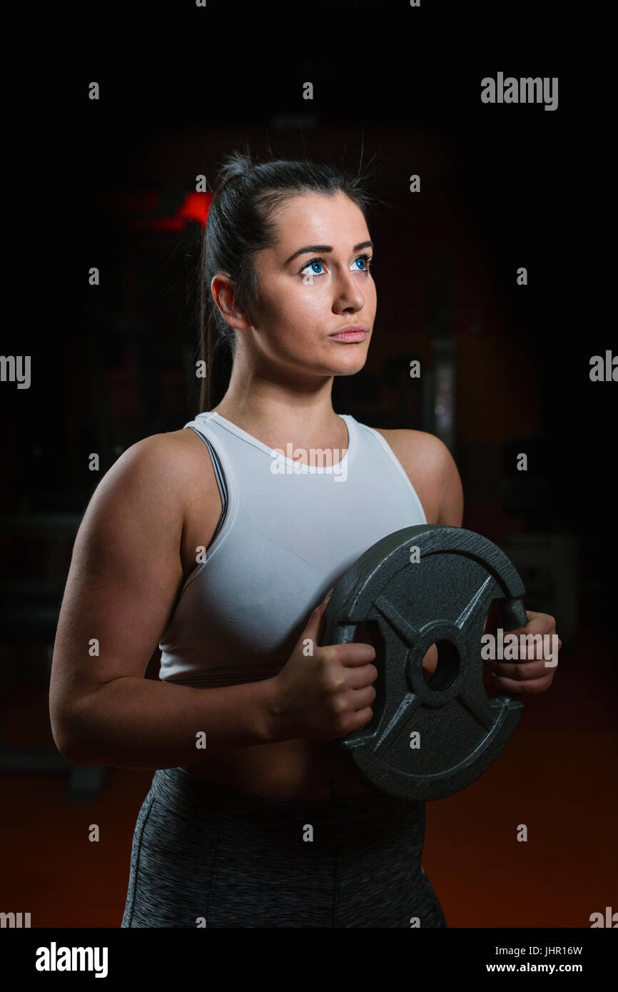 Strong young woman with beautiful athletic body doing exercises with ...