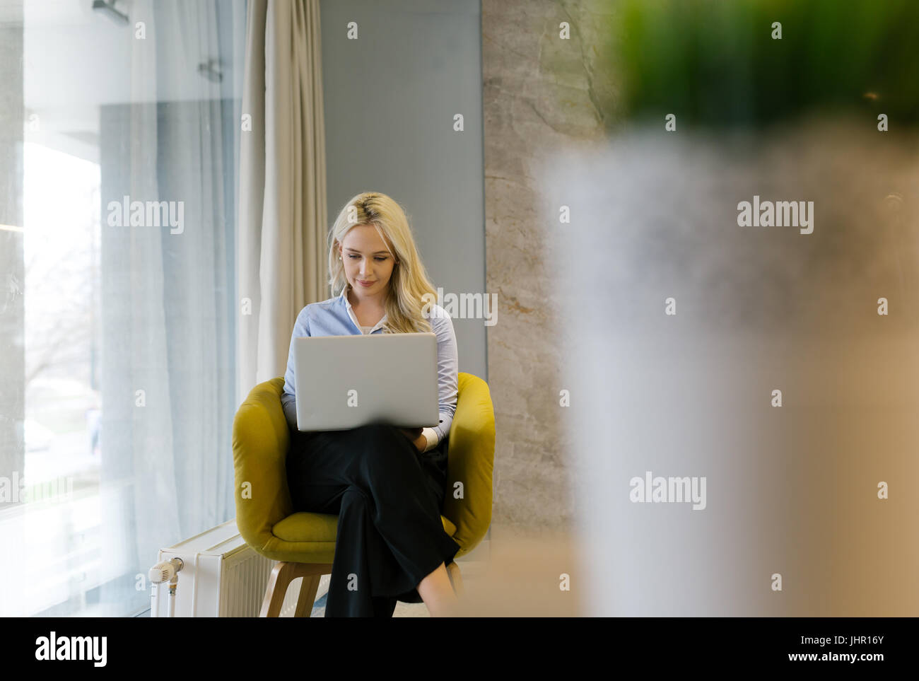 Portrait of a stunning fashionable model sitting in a chair. Business ...